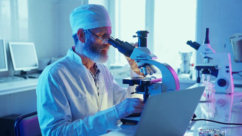 Chemist Analyzing Samples Using Microscope in Neon Purple Laboratory ...