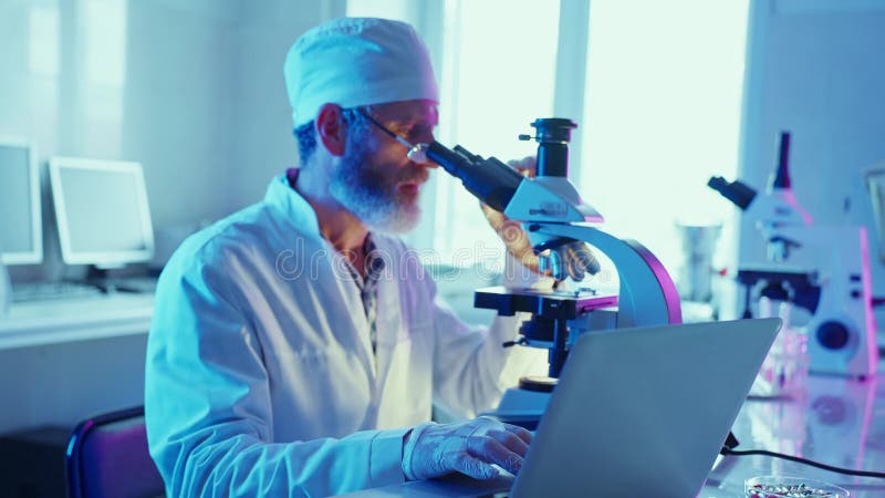 Chemist Analyzing Samples Using Microscope in Neon Purple Laboratory ...