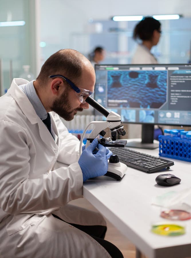 Chemist Doctor Looking through Microscope at Virus Sample Stock Photo ...