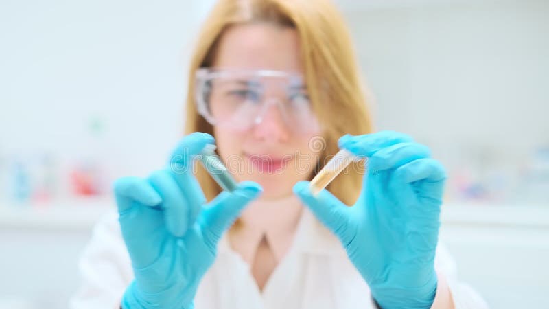 Chemist in Goggles Shaking Test Tubes with Blue and Yellow Solution ...