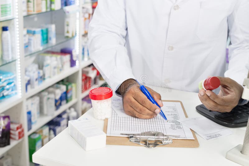 Chemist Holding Pill Bottle while Writing on Paper Stock Image - Image ...