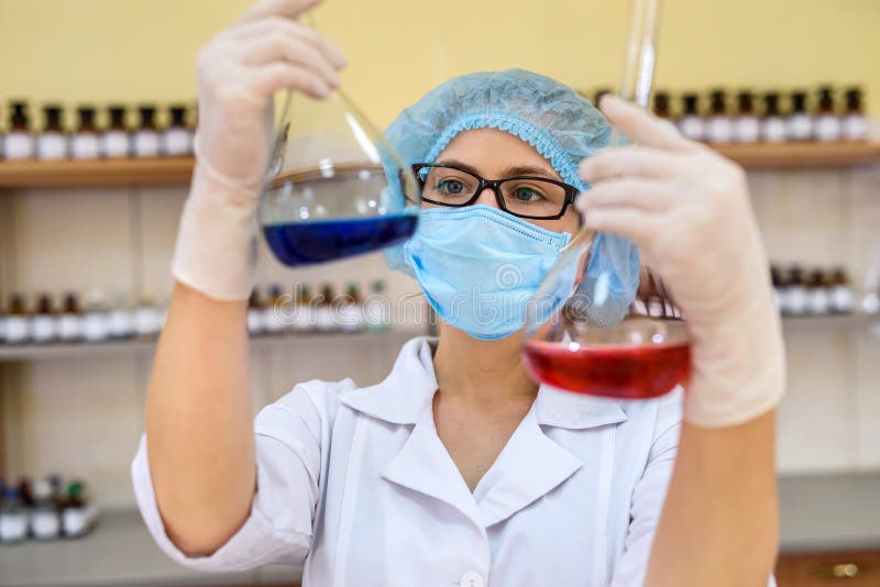 Chemist in Laboratory Looking at Flask with Liquid Substance Stock ...