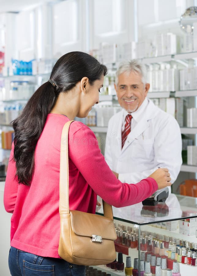 Chemist Looking at Customer Making Payment at Counter Stock Photo ...