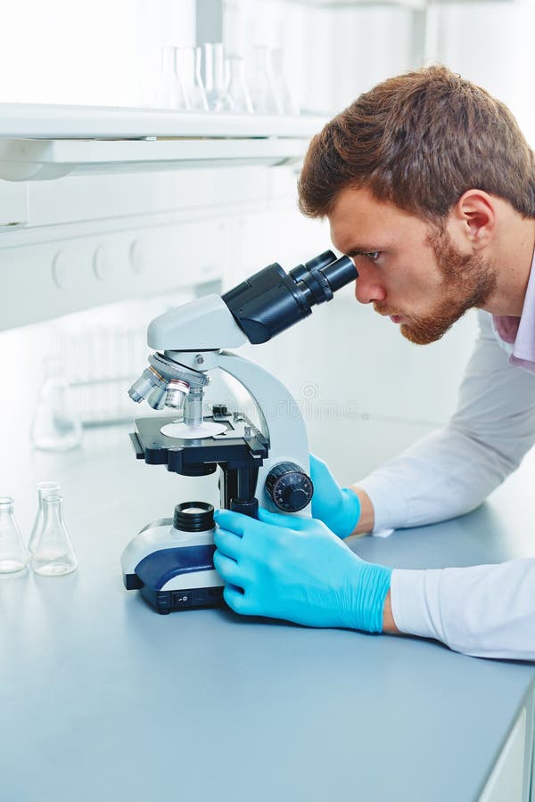 Chemist with microscope stock photo. Image of science - 69775354