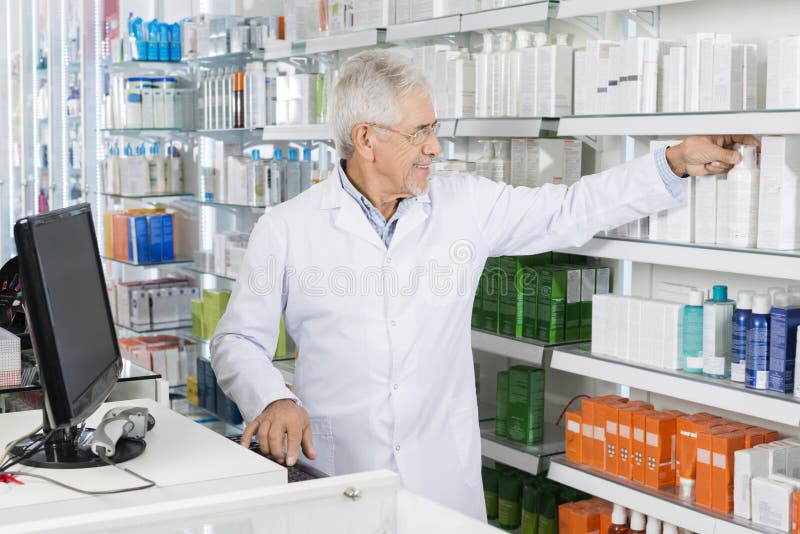 Chemist Removing Bottle from Shelf while Working on Computer Stock ...