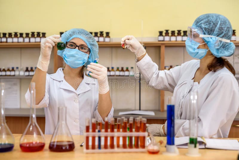 Chemists Working in Laboratory. Young Women in Protective Uniforms with ...