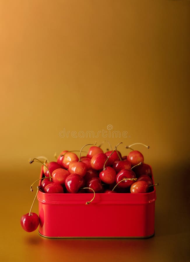 Cherries in a Red Metal Box on a Gold Background. Stock Image - Image ...