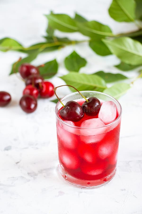 Cherry Fruit Drink in a Glass Cup, Cherry Berries and Green Leaves on a ...