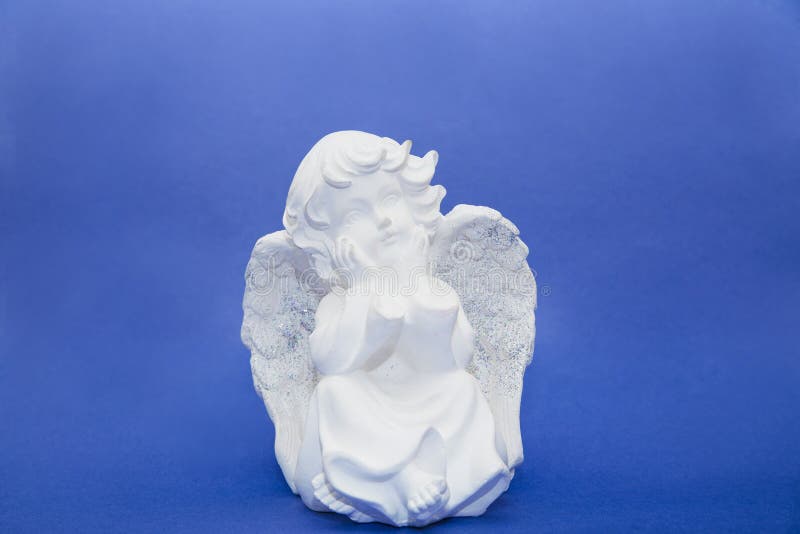Cherub statuette on blue stock photo. Image of gypsum - 65484522