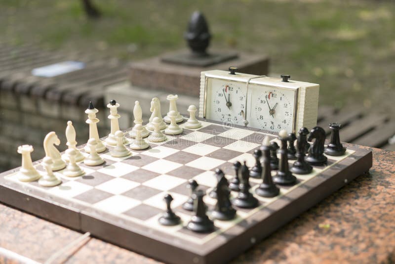 Chess Board with Pieces and Clock on Wooden Desk in Connection with the ...