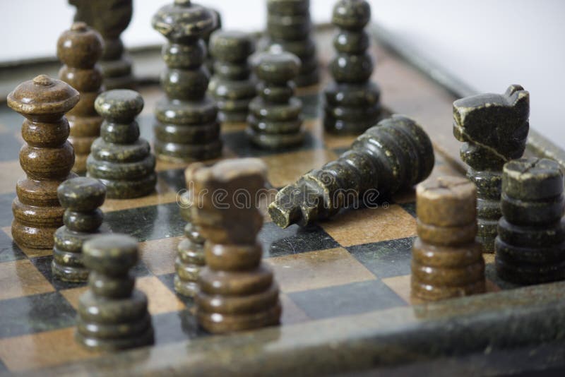 King among Fallen Chess Pieces on Black Table Against Dark Background ...