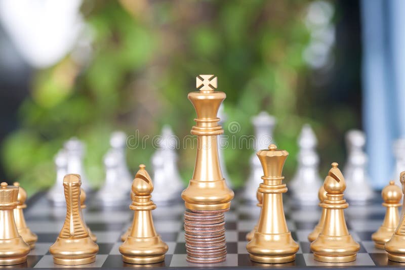 Chess Pieces on a Chess Board with Golden King Pieces on a Stack of ...