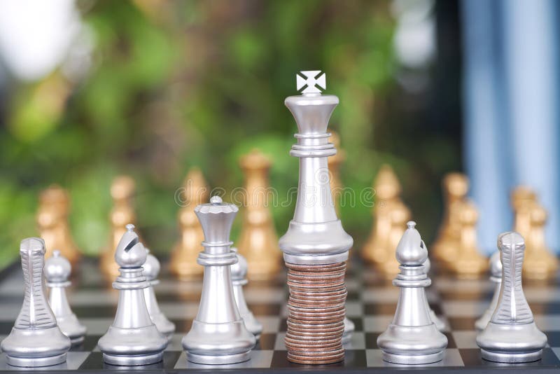 Chess Pieces on a Chess Board with Silver King Pieces on a Stack of ...