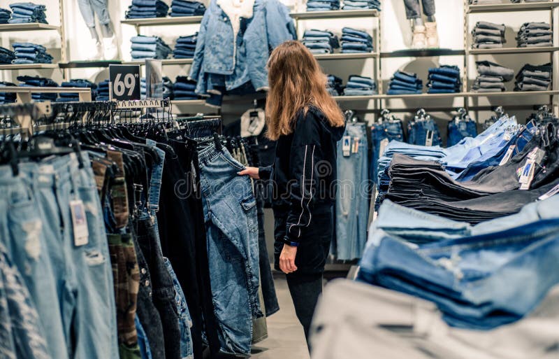 Chica Sonriente Comprando Jeans Nuevos En La Tienda Fotografía ...