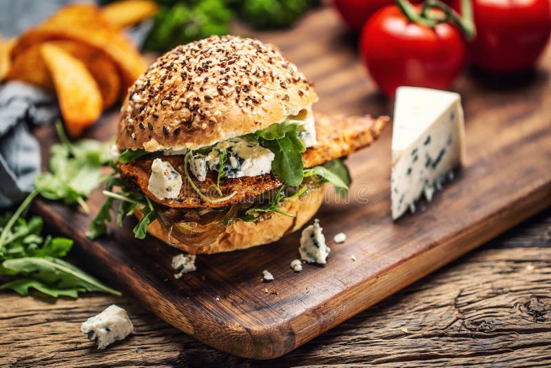 Chicken Burger with Blue Cheese and Arugula in a Sesame Bun on a Rustic ...