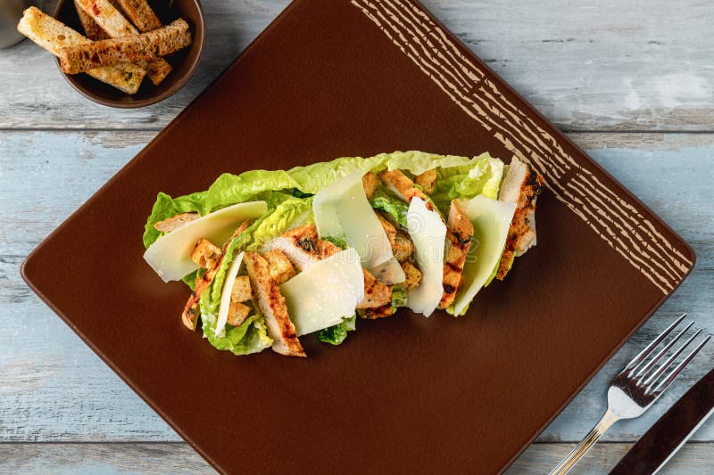 Chicken Caesar Salad Served on a Porcelain Plate with Crusty Bread ...