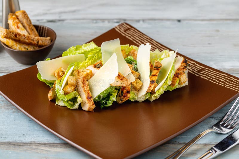 Chicken Caesar Salad Served on a Porcelain Plate with Crusty Bread ...