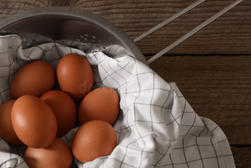 Chicken Eggs in Colander with Napkin on Wooden Table, Top View. Space ...