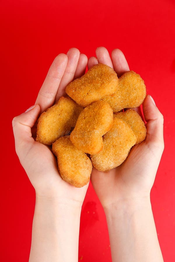 Chicken Nuggets on the Hand Palms, Isolated on Red Background, Vertical ...