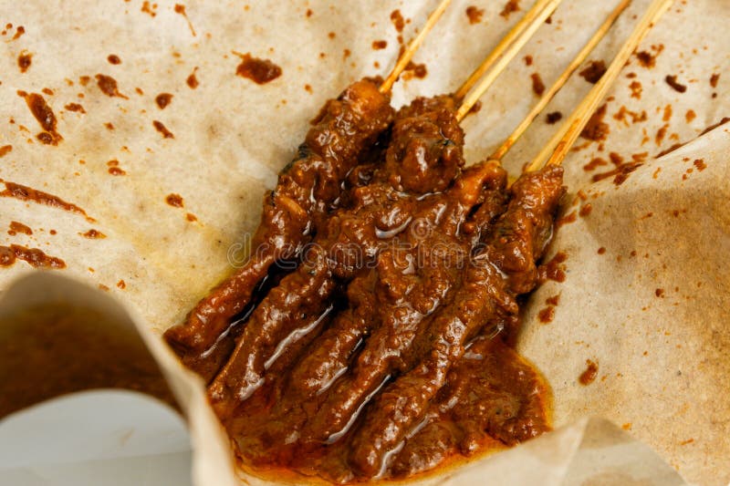 Chicken Satay Dipped in Peanut Sauce on the Brown Paper Pack Stock ...