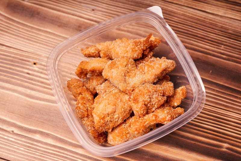 Chicken Strips in a Plastic Container on a Wooden Table Stock Photo ...