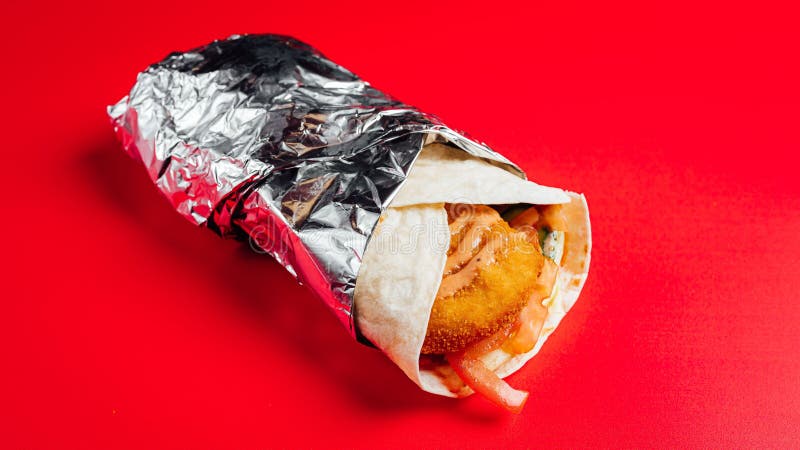 Chicken Wing Wrap Rolled in Tin Foil on a Red Background Stock Photo ...