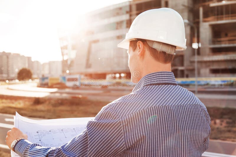 Chief Engineer with a Drawing in Hand Looking at the Construction Site ...