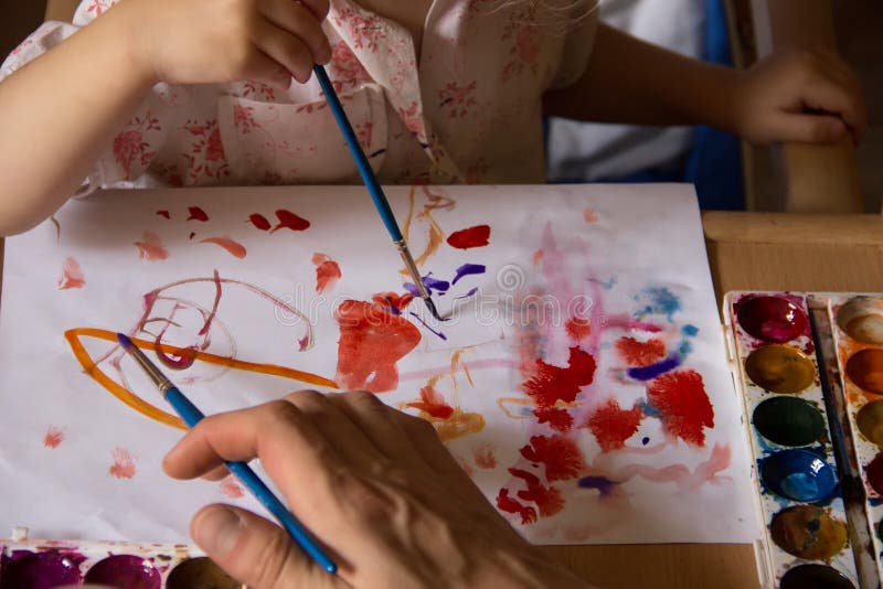 A Child with an Adult Engaged in Drawing Paints. Stock Image - Image of ...