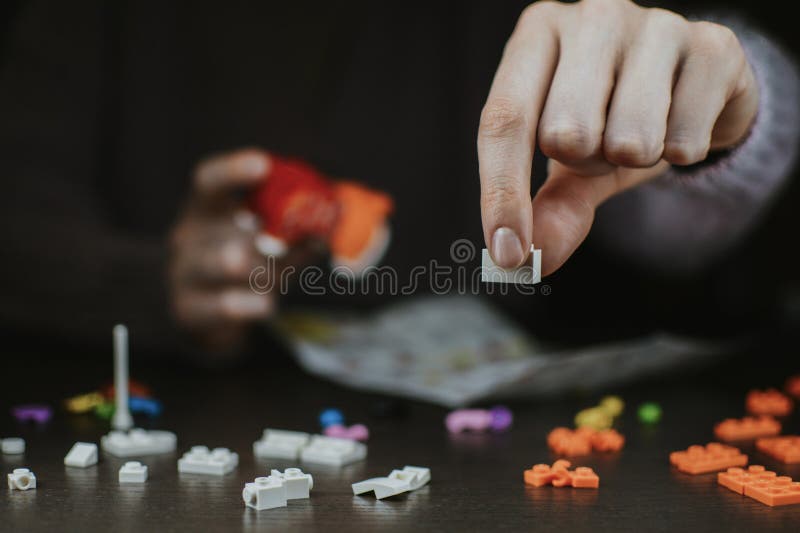 A Child Assembles Multi-colored Lego Blocks with His Own Hands Stock ...