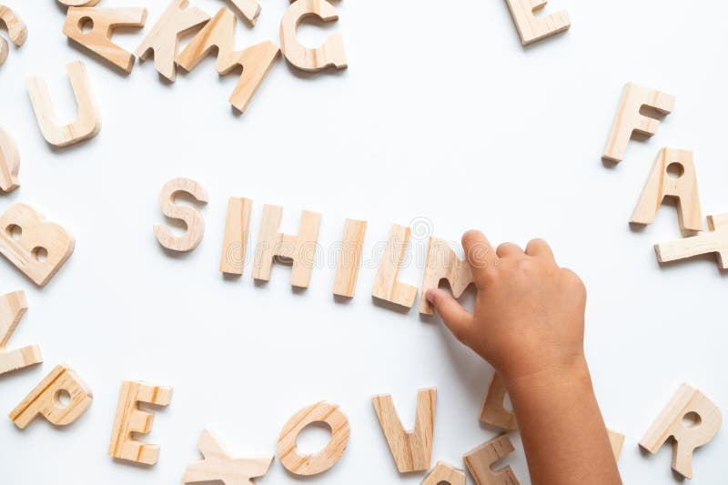 Child Assembling Wooden Alphabet Letters on White Surface Stock Photo ...