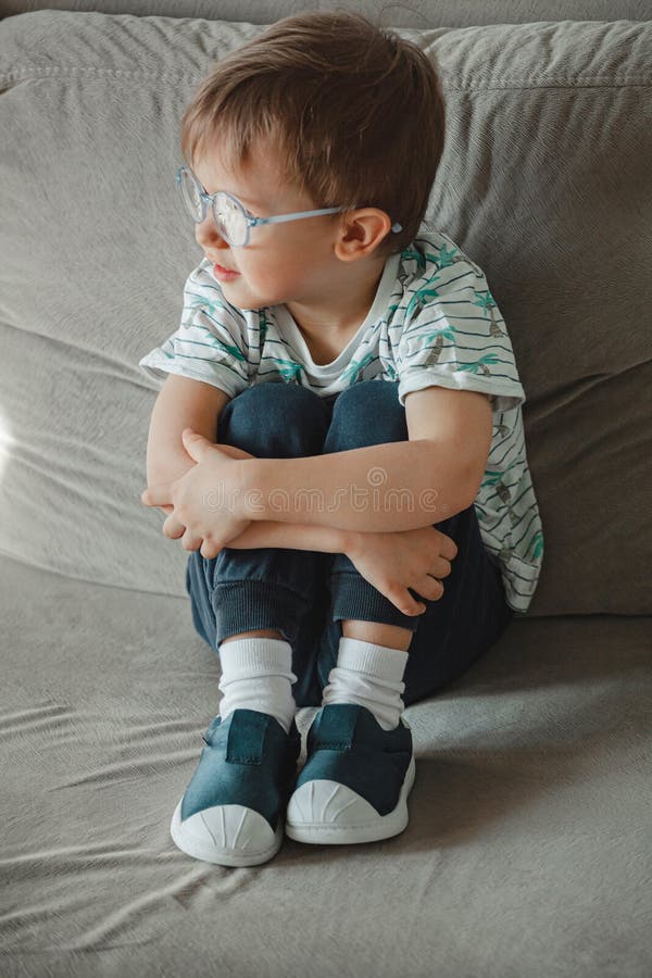 A Child with Autism in Glasses Sits on the Sofa and Sad, Angry a Stock ...