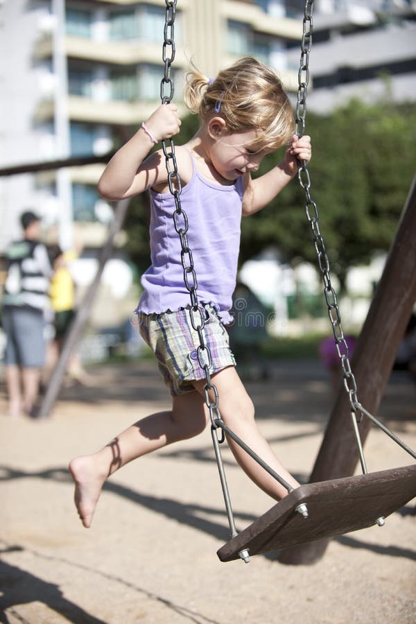 Child Balancing on Swing, Urban Playground Stock Photo - Image of ...