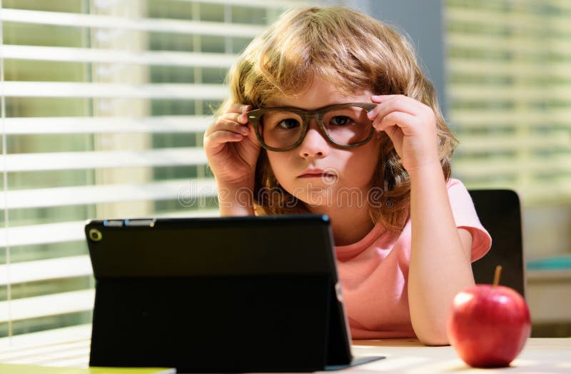 Child Boy in Glasses Using a Tablet and Study Online with Video Call ...