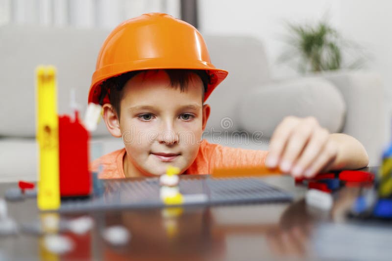 Child Boy in Helmet Playing and Building with Colorful Plastic Bricks ...