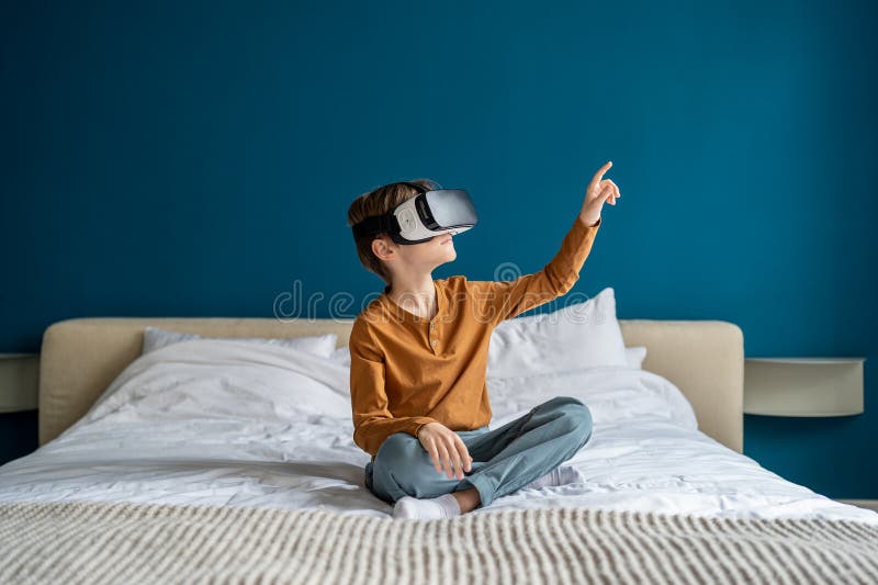 Child Boy Wearing Virtual Reality Headset Sitting on Bed at Home ...