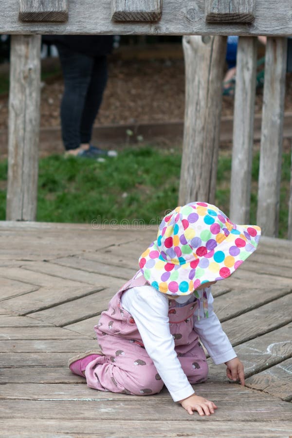 Child in Bright Spotty Hat Playing on Wooden Platform Stock Image ...