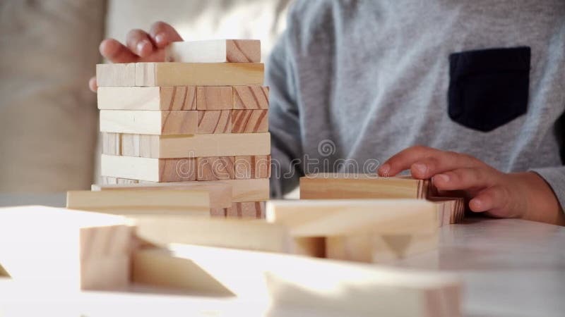 Child Build a Tower from Wooden Blocks Sitting on the Sofa at Home ...