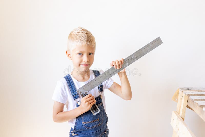 Child Builder Measures a White Wall with a Construction Ruler, Space ...