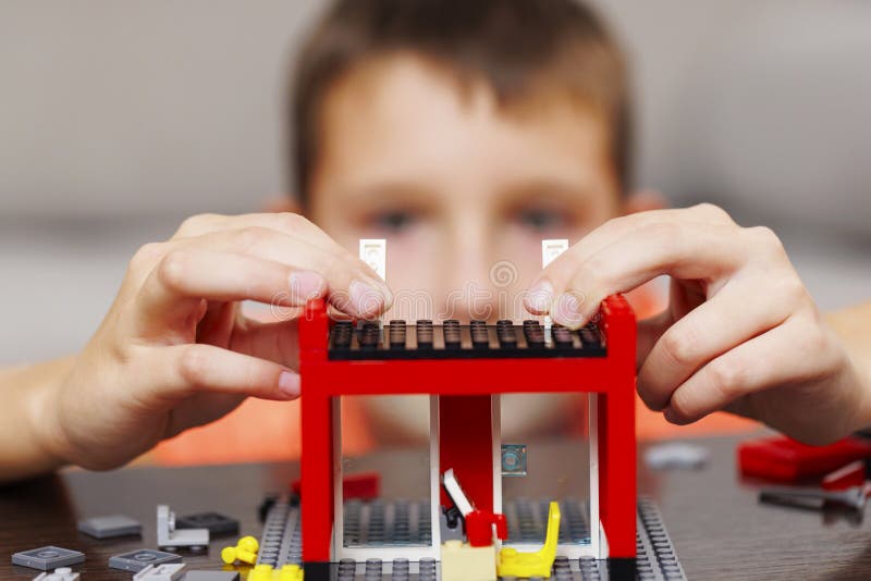 Child Building a Red Toy Structure with Blocks on a Table Stock Photo ...