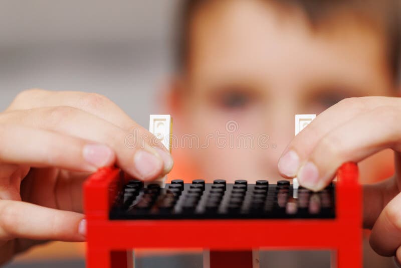 Child Building a Red Toy Structure with Blocks on a Table Stock Image ...
