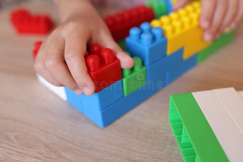 Child Builds a House from a Constructor of Colored Bricks, Hands Close ...