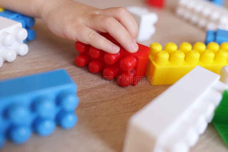 Child Builds a House from a Constructor of Colored Bricks, Hands Close ...