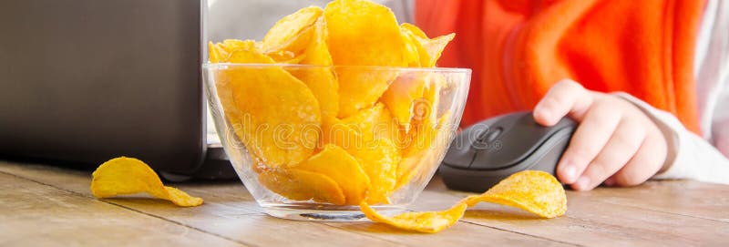 Child with Chips Behind a Computer. Selective Focus Stock Image - Image ...