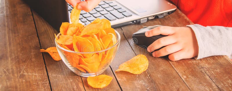 Child with Chips Behind a Computer. Selective Focus Stock Image - Image ...