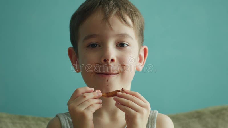 Child with a Chocolate-stained Face Joyfully Eats Bread with Chocolate ...