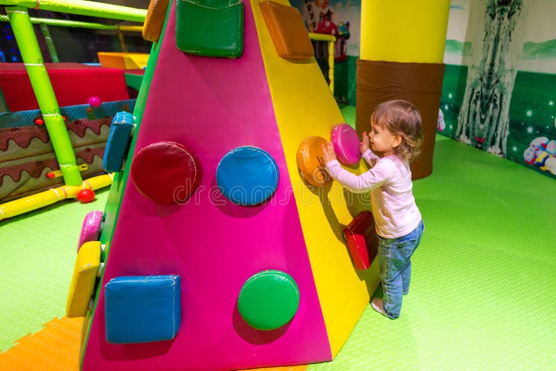 A Child Climbing a Bright and Colorful Soft Pyramid in a Safe Indoor ...