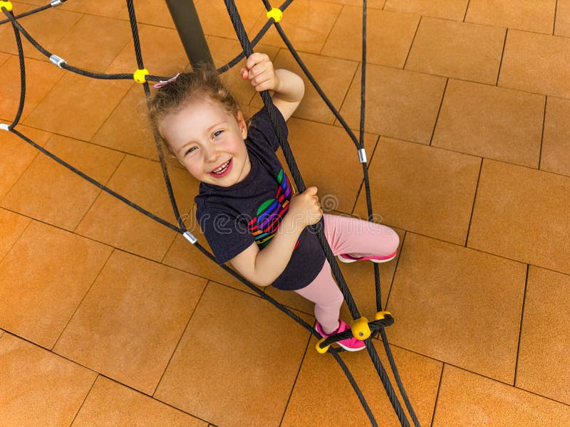 A Child Climbs on an Attraction with Ropes. Stock Image - Image of ...