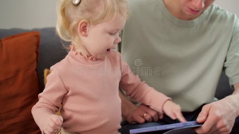 A Child with Cochlear Implants Plays with a Tablet Computer with His ...