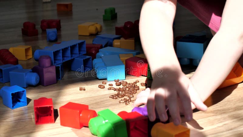 Child Collects Sweets Scattered on the Floor between the Constructor ...
