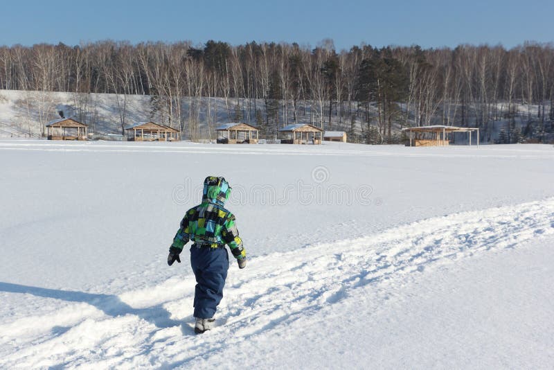 The Child in a Color Jacket Going, on Snow in the Winter Stock Photo ...